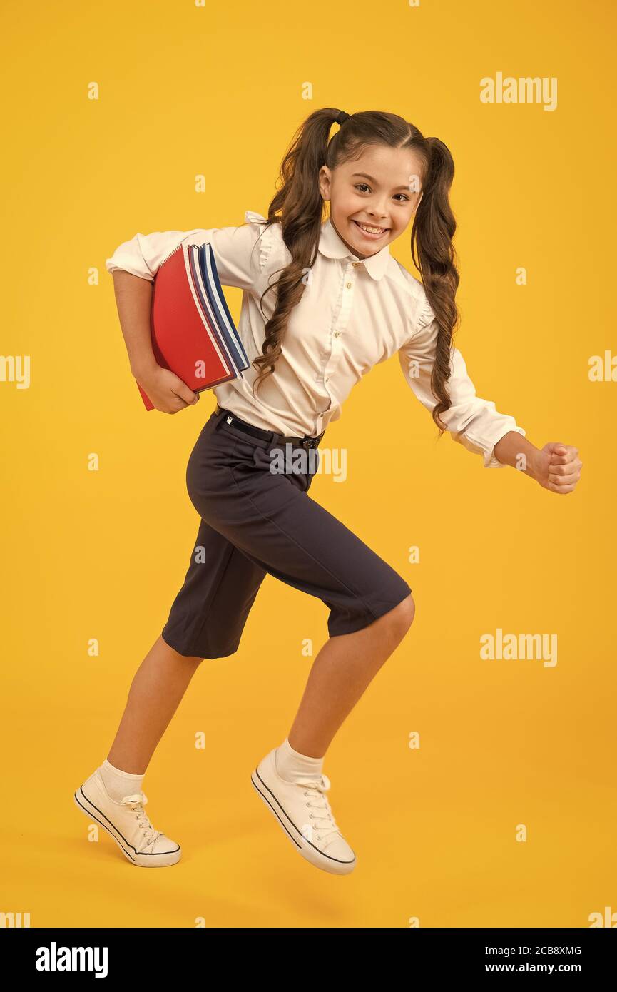 Hurry to the library. Cute small child running to library on yellow ...