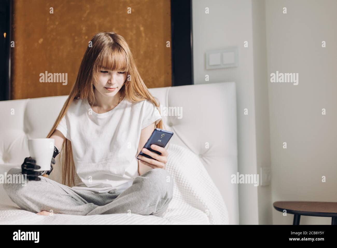 The young girl spending her free time with gadget at home, close up ...