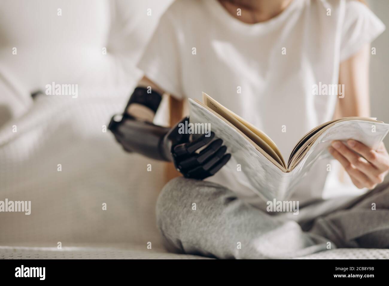 woman's artificial arm holding a book, close up photo. blurred image ...