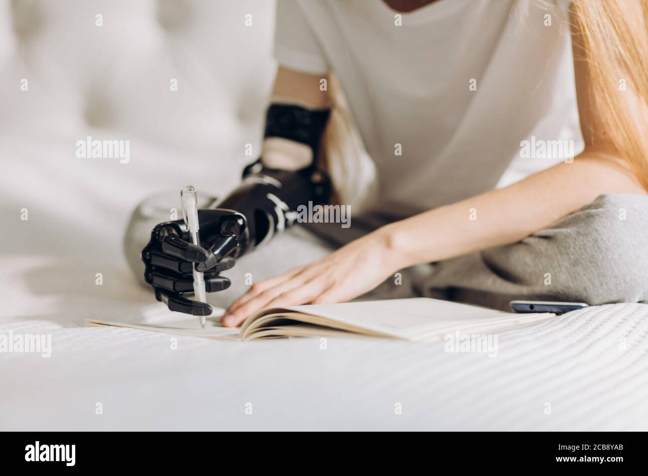 disabled girl learning to write with a prosthetic arm. close eup ...