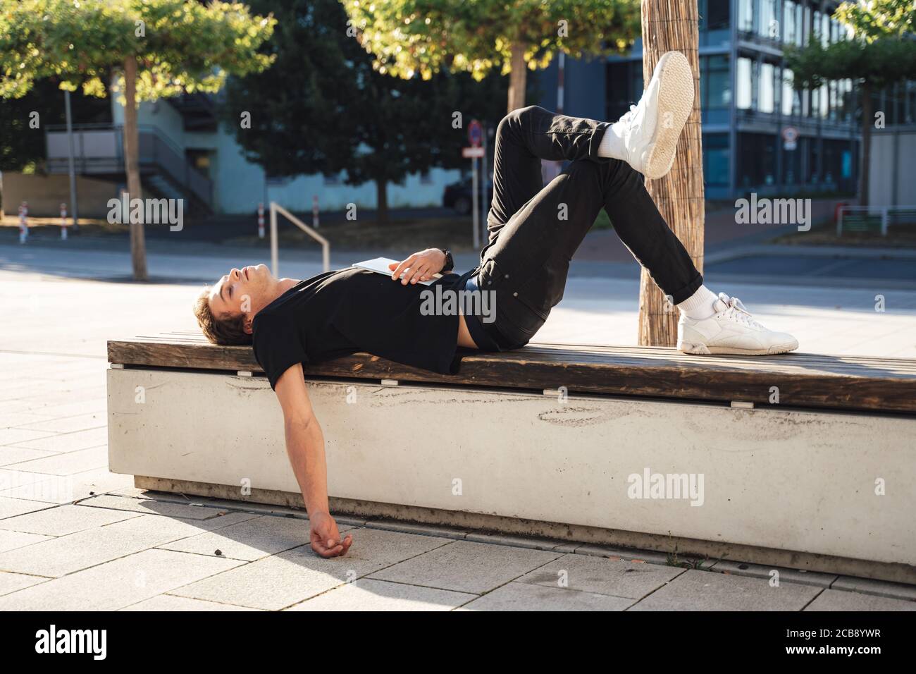 Young man sleeping on bench hi-res stock photography and images - Alamy