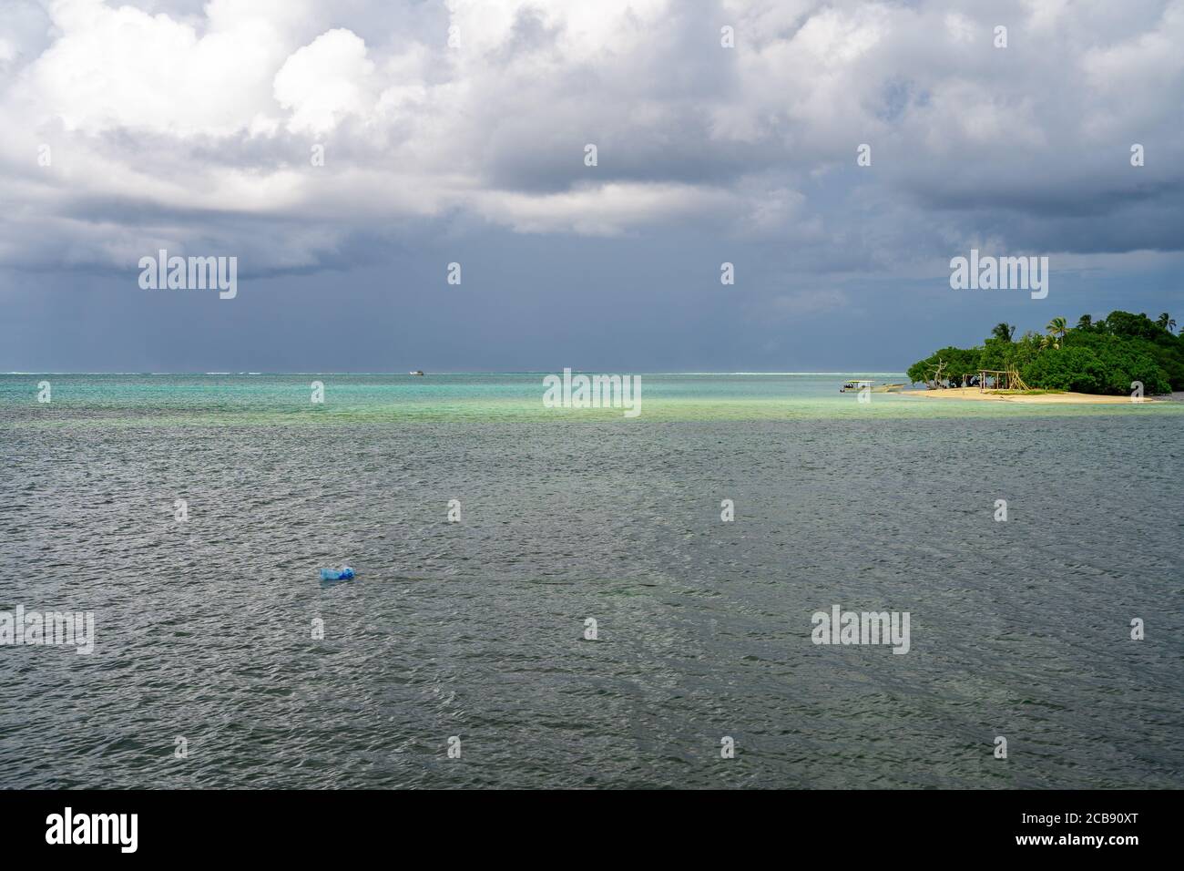 Ocean waves hitting the sandy beach and gleaming under the cloudy sky ...