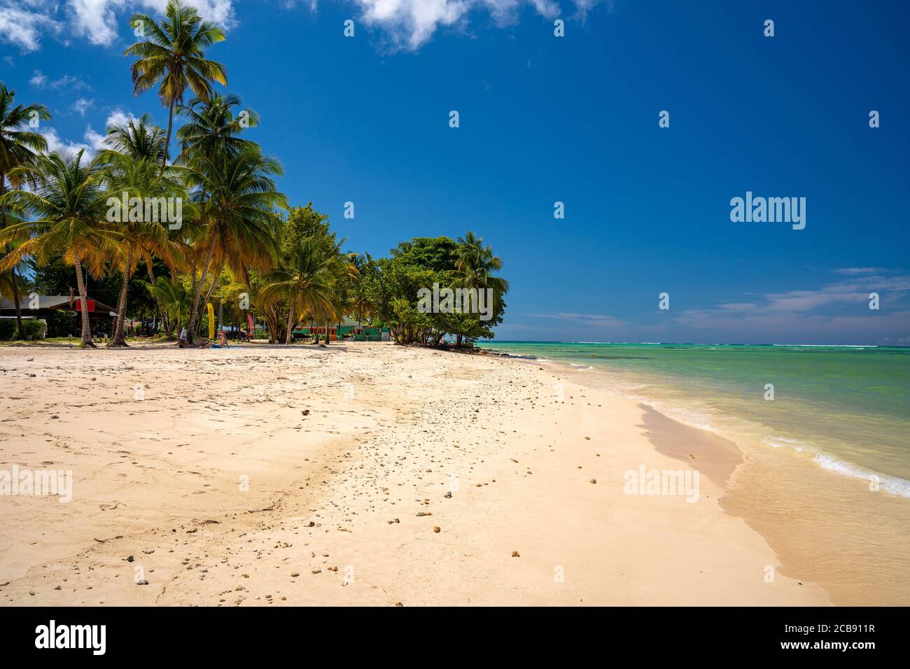Ocean waves hitting the sandy beach and gleaming under the cloudy sky ...