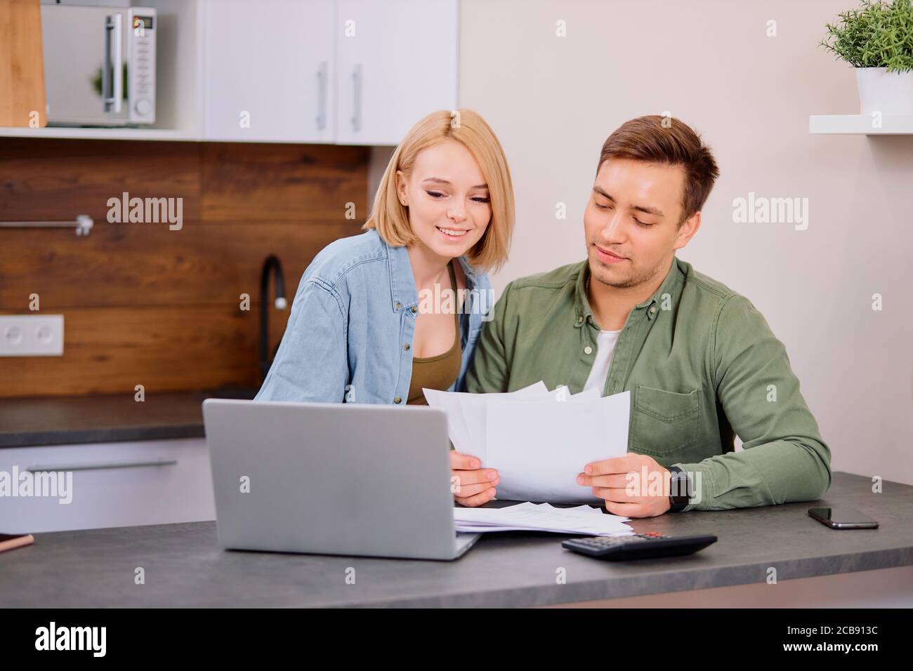 couple checking analyzing utilities bills sitting together at kitchen ...