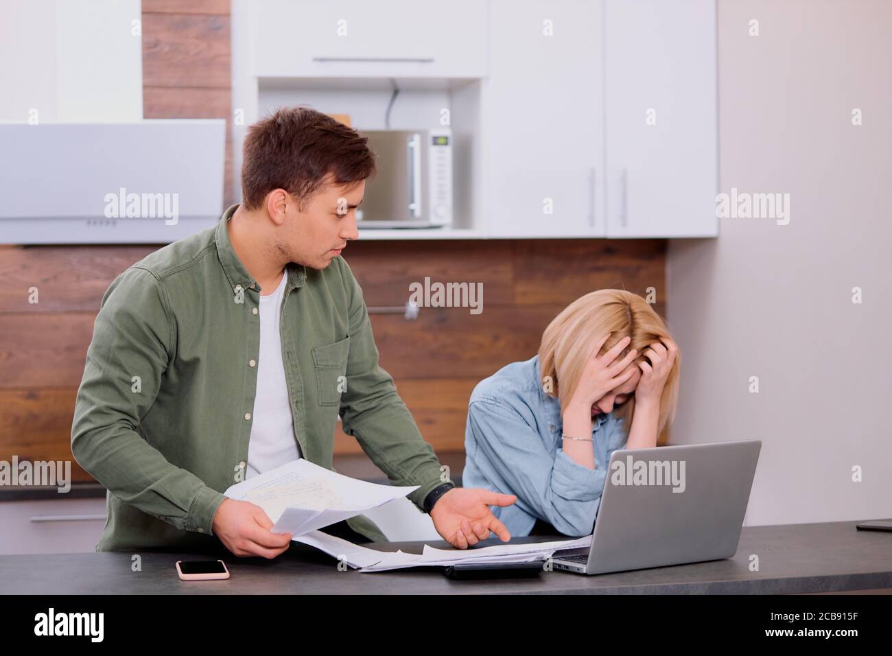 couple using modern laptop computer, looking worried and sad, studying ...