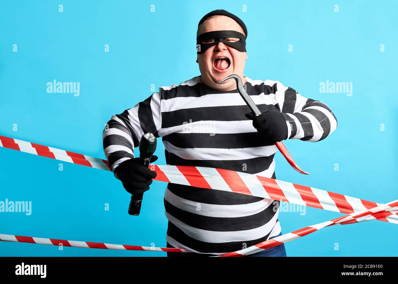 happy young man trying to escape the police, isolated blue background ...