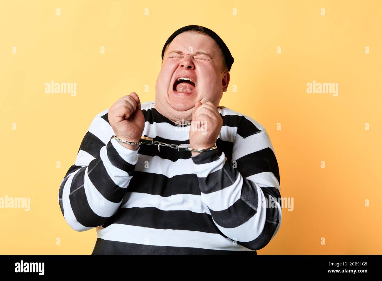angry frustrated thief with closed eyes in handcuff crying. emotion and ...
