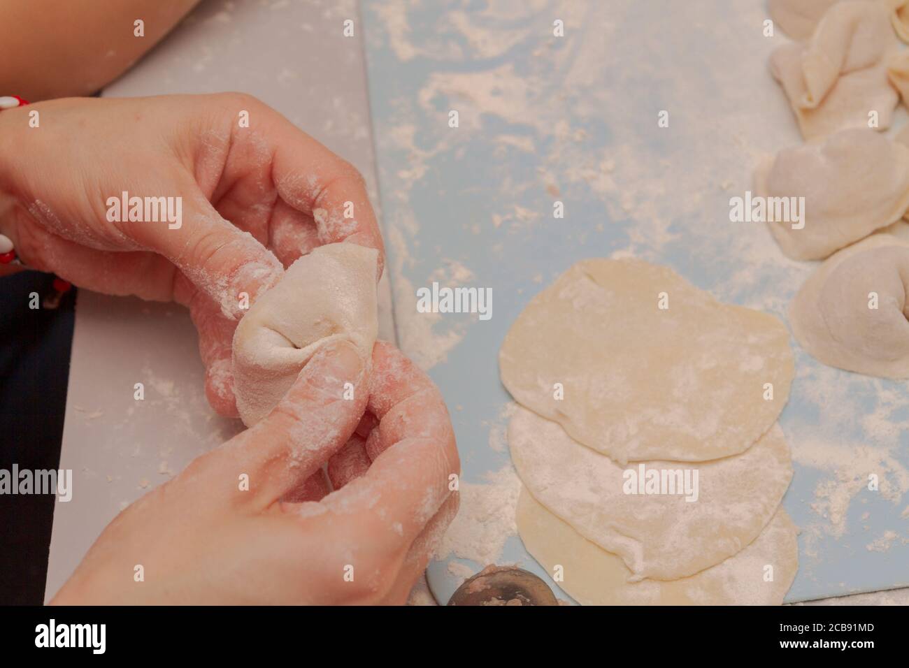 Modeling and cooking homemade dumplings woman chef at home Stock Photo ...