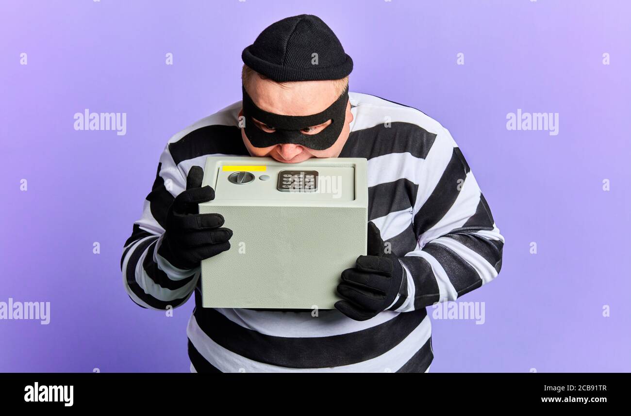fat plump prisoner in striped clothes opening the safe with teeth ...