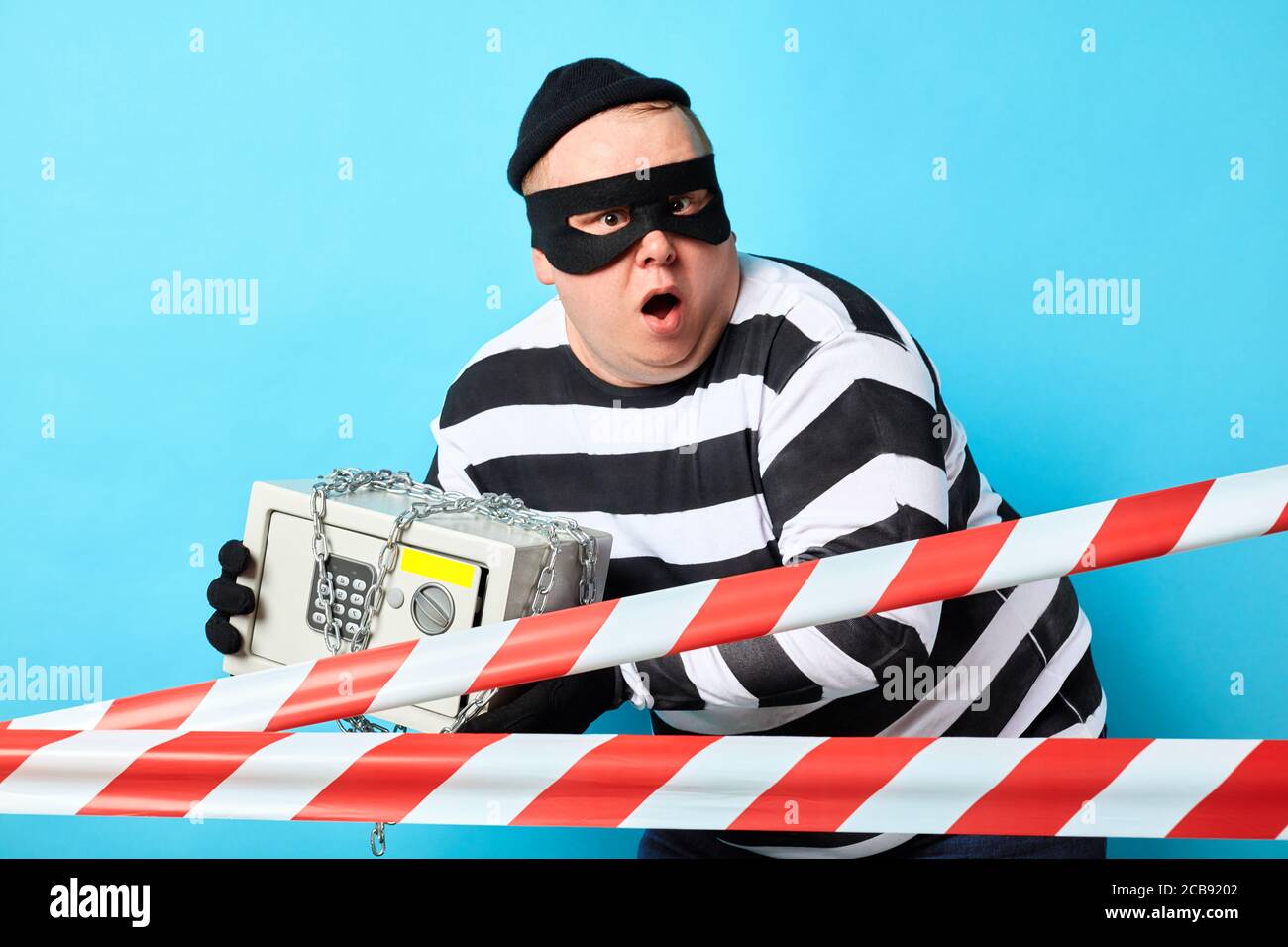 surprised scared burglar trying to hide safe from policemen. isolated ...