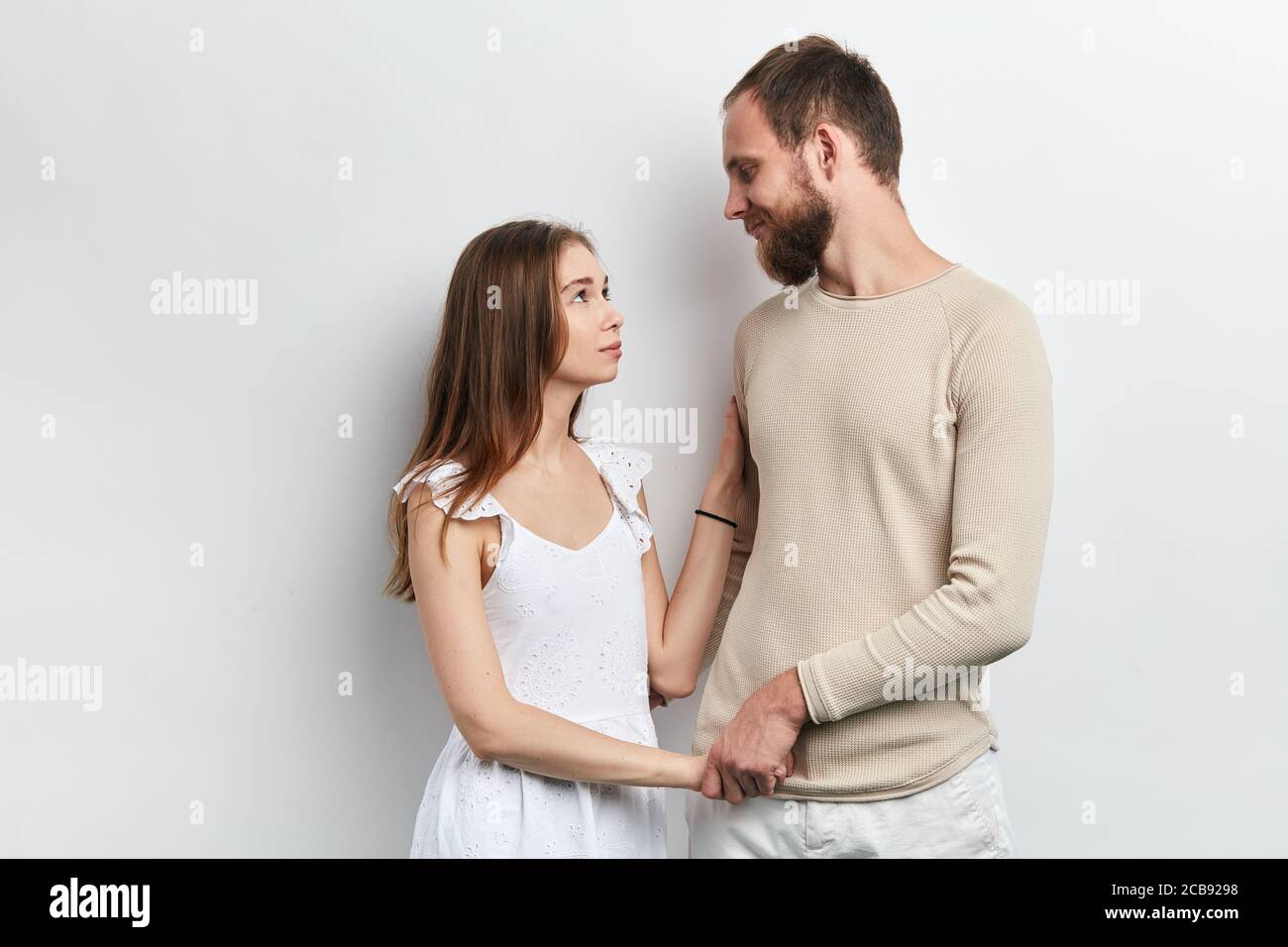 young handsome man holding his girlfriend's hand gives a wods of praise ...