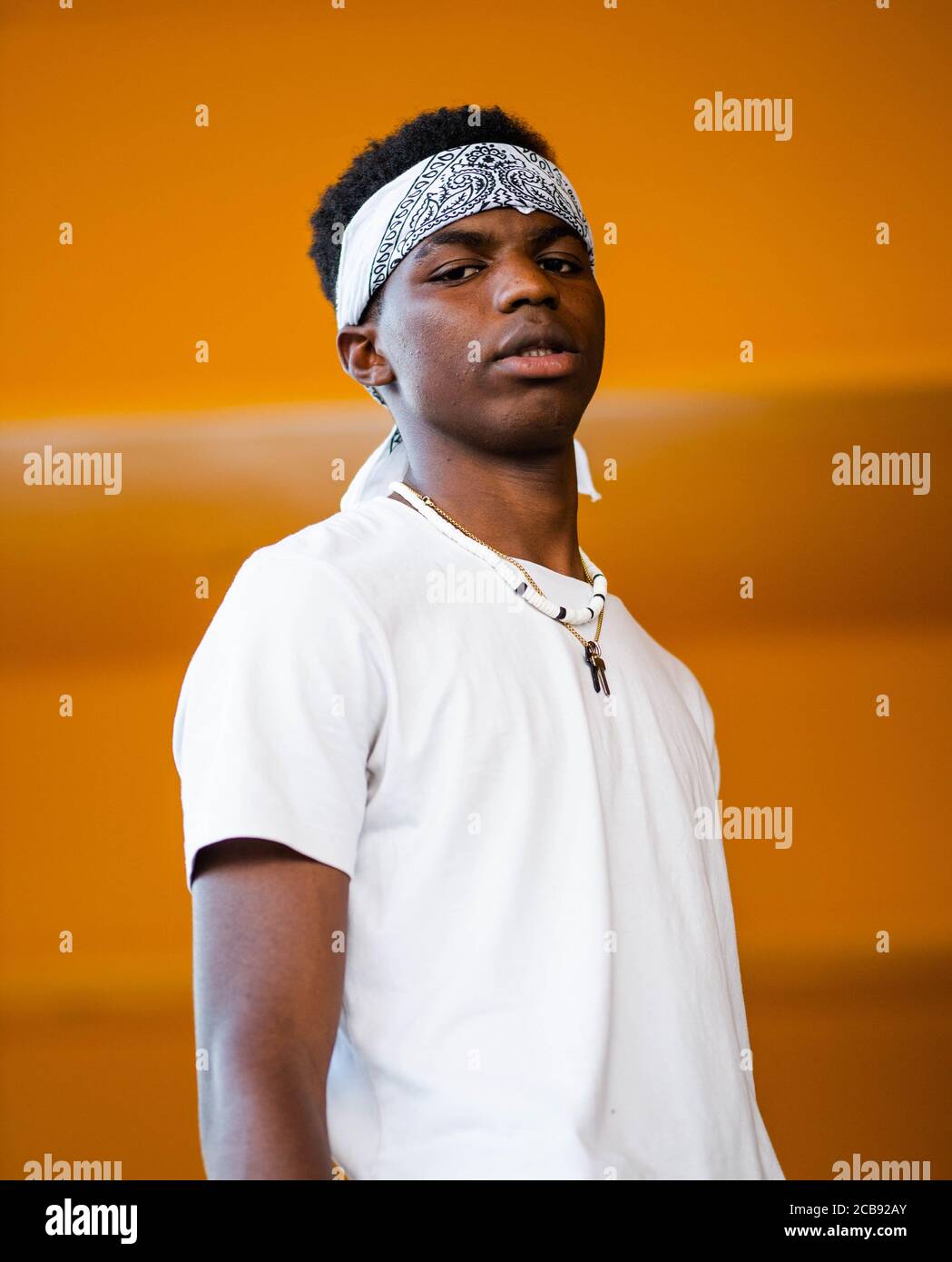 Shallow focus shot of a young black male on a yellow wall background ...