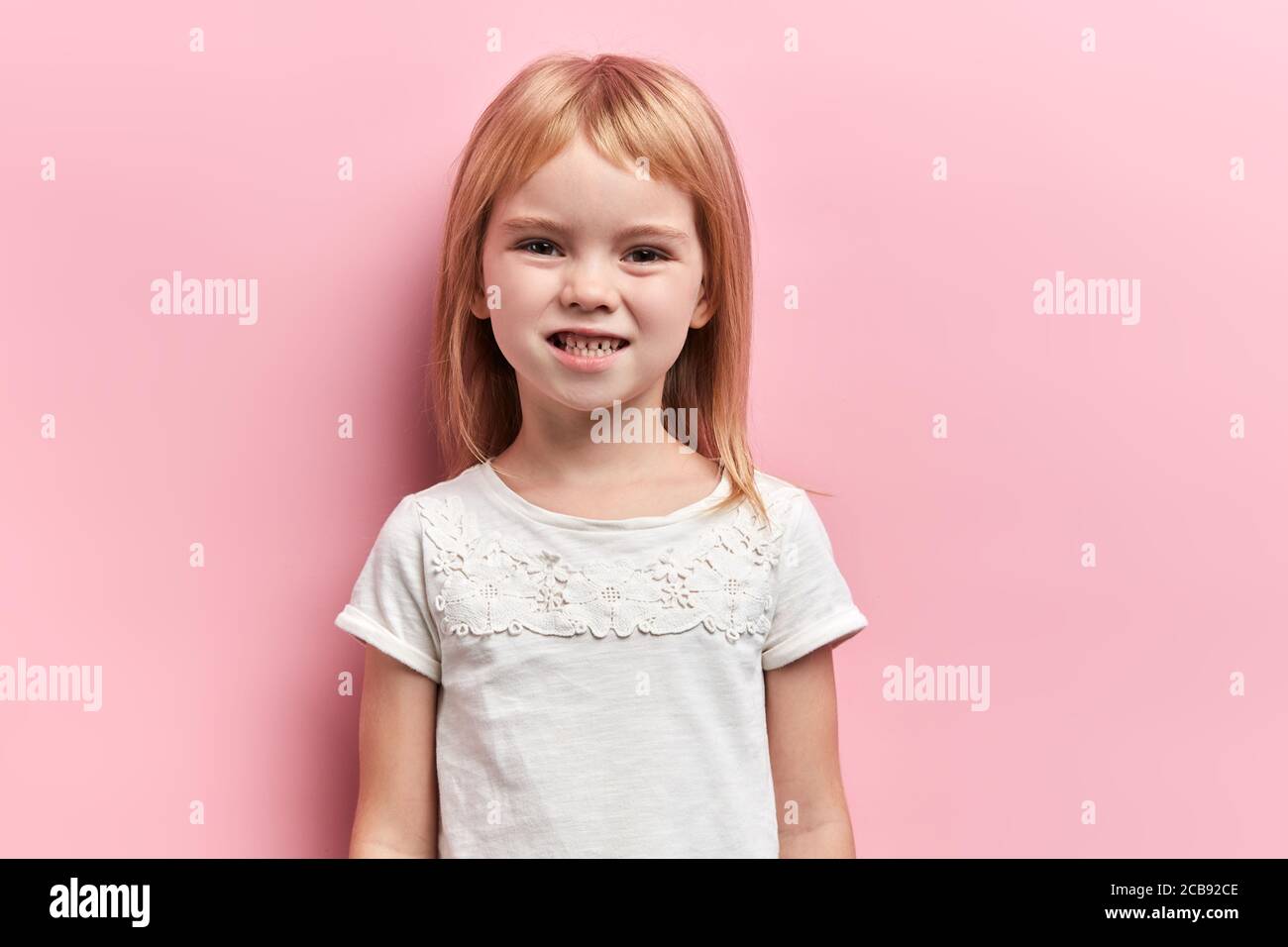 Little cute angry girl clenching her teeth. close up portrait, isolated ...