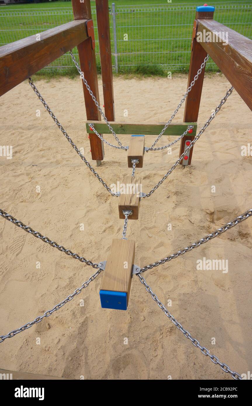 Vertical shot of wooden blocks hanging on metal chains of a equipment ...