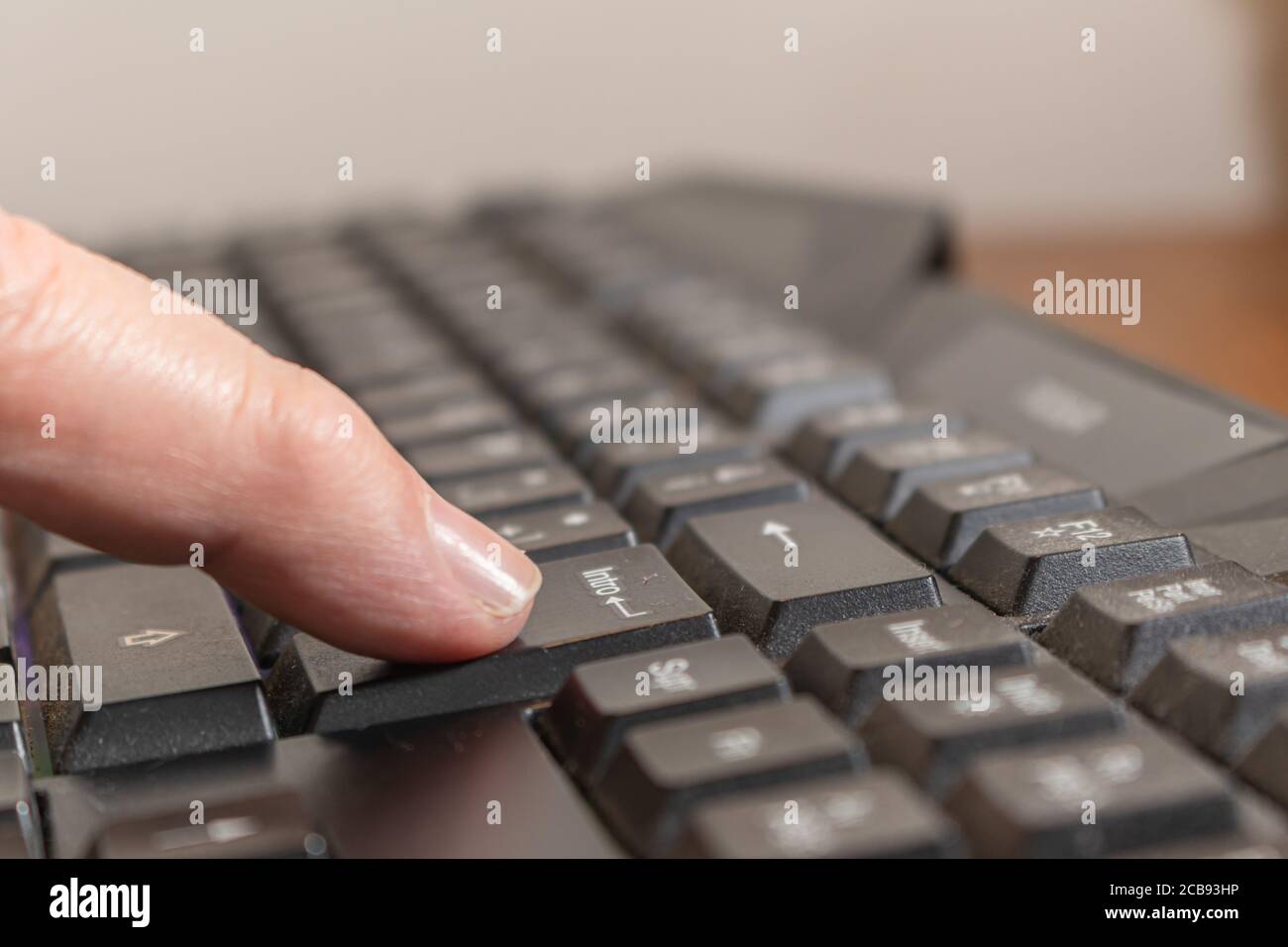 Finger pressing the enter key on a black computer keyboard Stock Photo ...