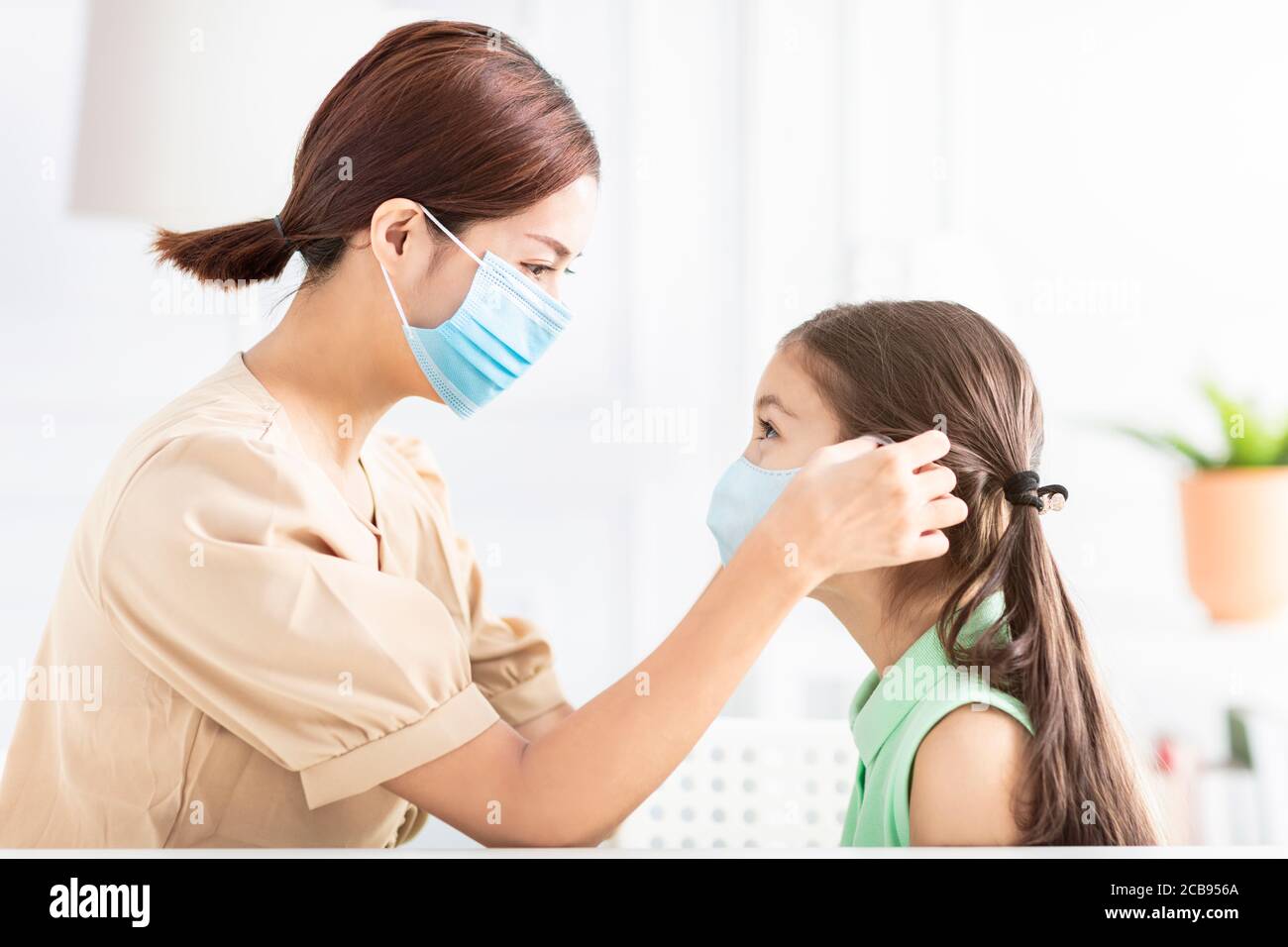 mother help her daughter wearing healthy face mask Stock Photo - Alamy