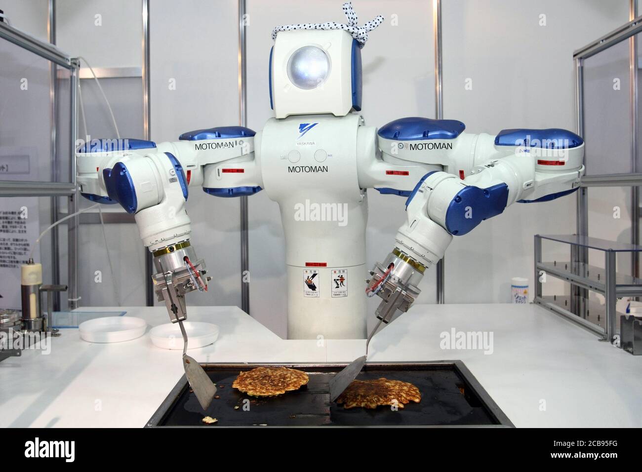 A robot cooks okonomiyaki (Japanese savory pancakes) during a ...