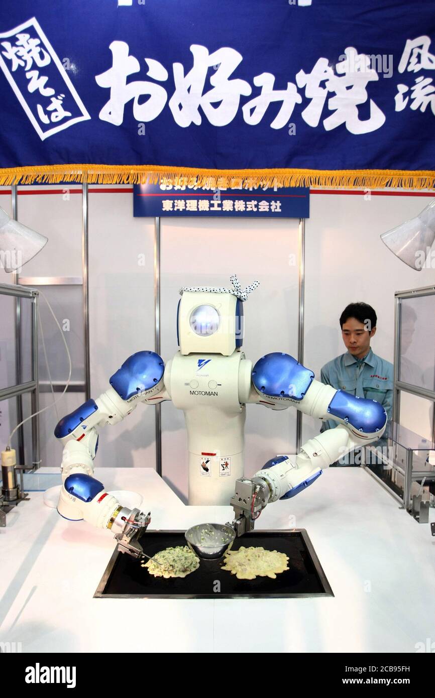 A robot cooks okonomiyaki (Japanese savory pancakes) during a ...