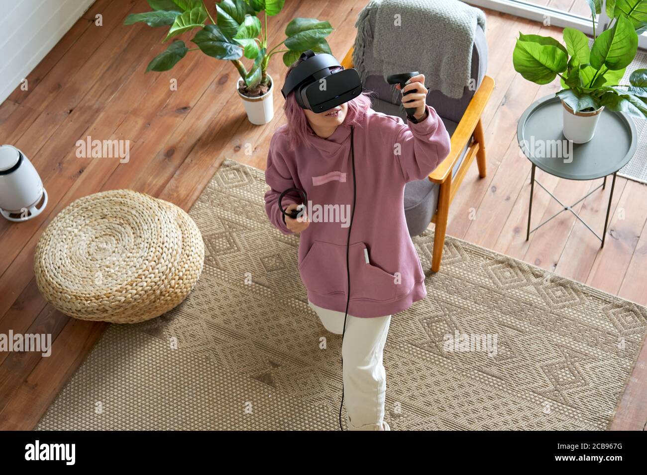 Teen girl wear vr goggles headset exploring virtual reality looking up ...
