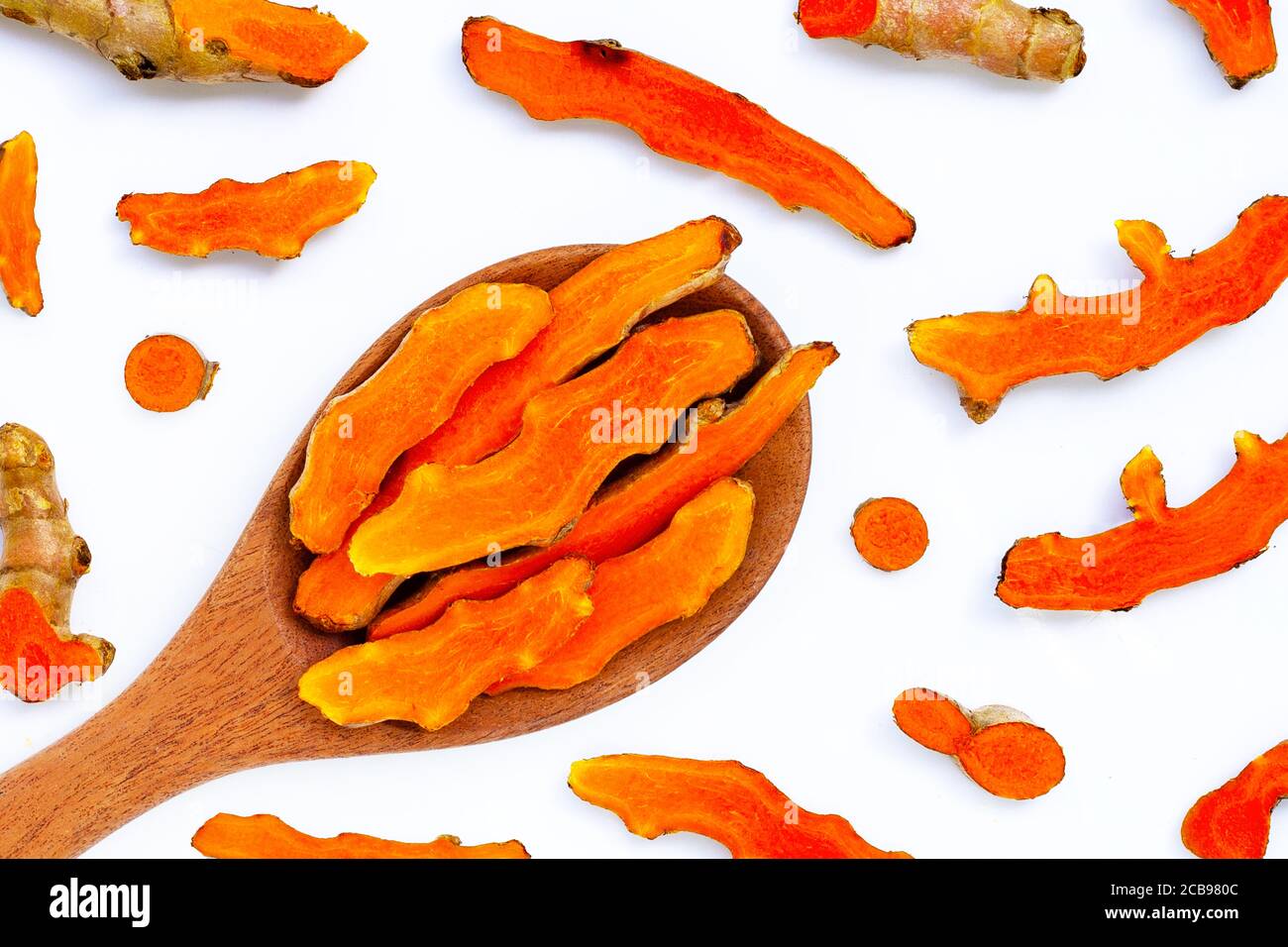 Cutting of turmeric roots on wooden spoon on white background Stock ...