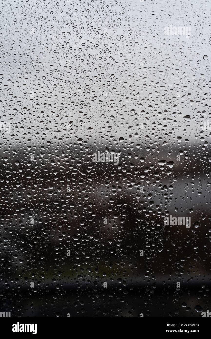 Raindrops on window against a blurry backdrop during storm Ciara ...