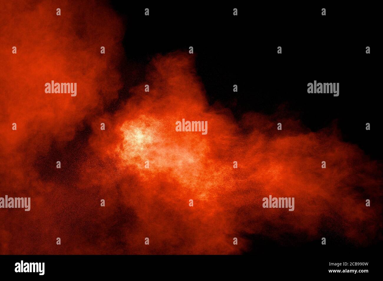 Abstract explosion of orange dust on black background.Freeze motion of ...