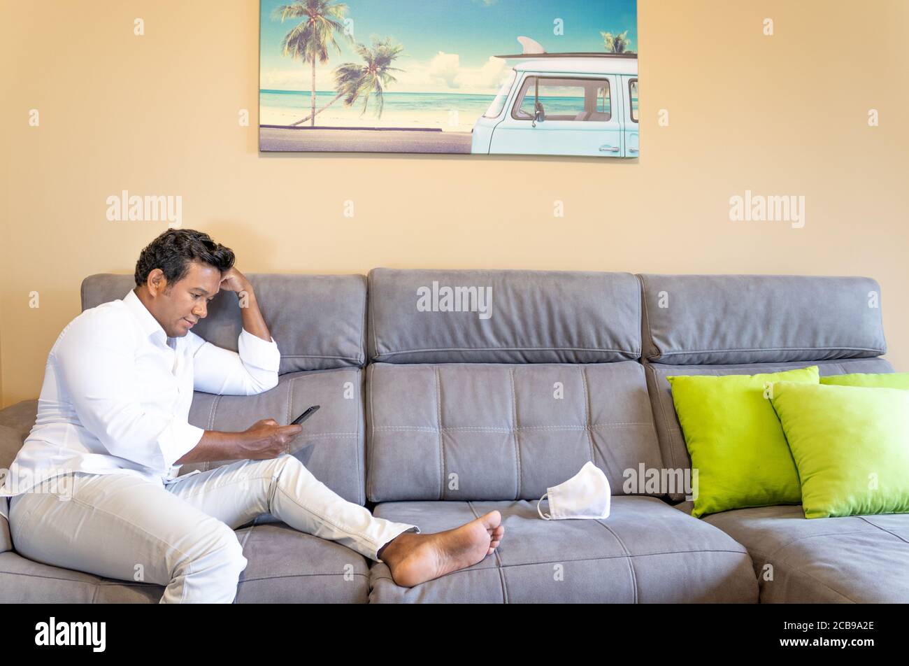 Teleworking man sitting on the couch at home. Laptop and mobile ...