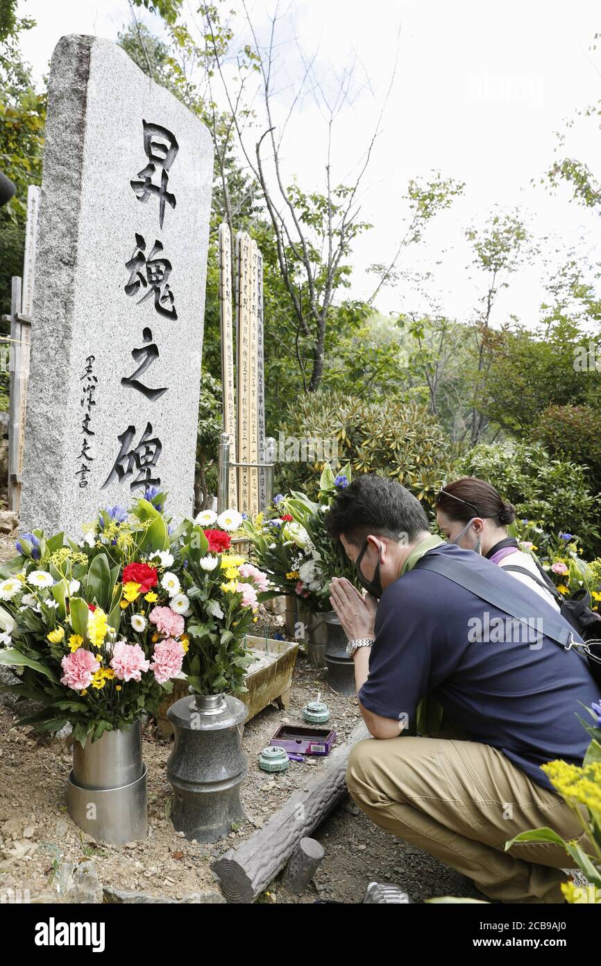 Tokyo, Japan. 12th Aug 2020. People pray at a monument dedicated to the ...