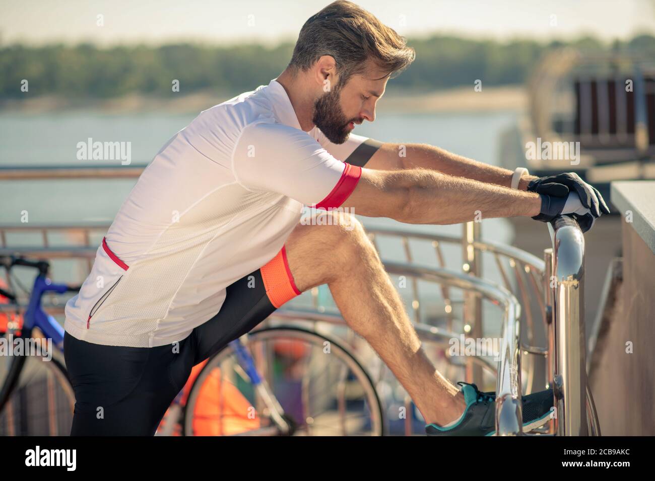 Concentrated young sportsman stretching hi-res stock photography and ...