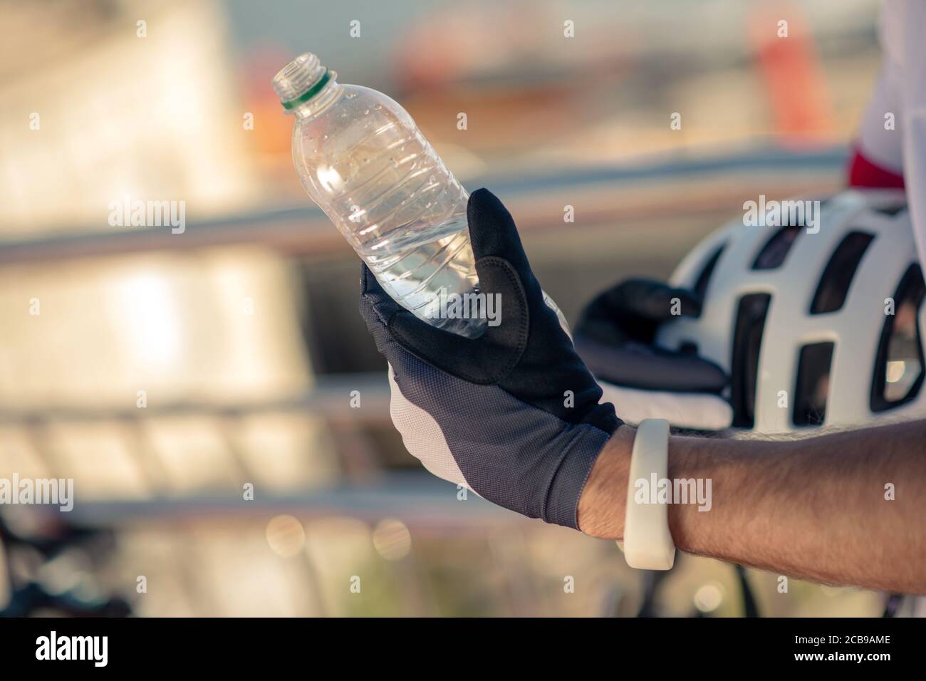 Bottle of water in mans hand in sports glove Stock Photo - Alamy