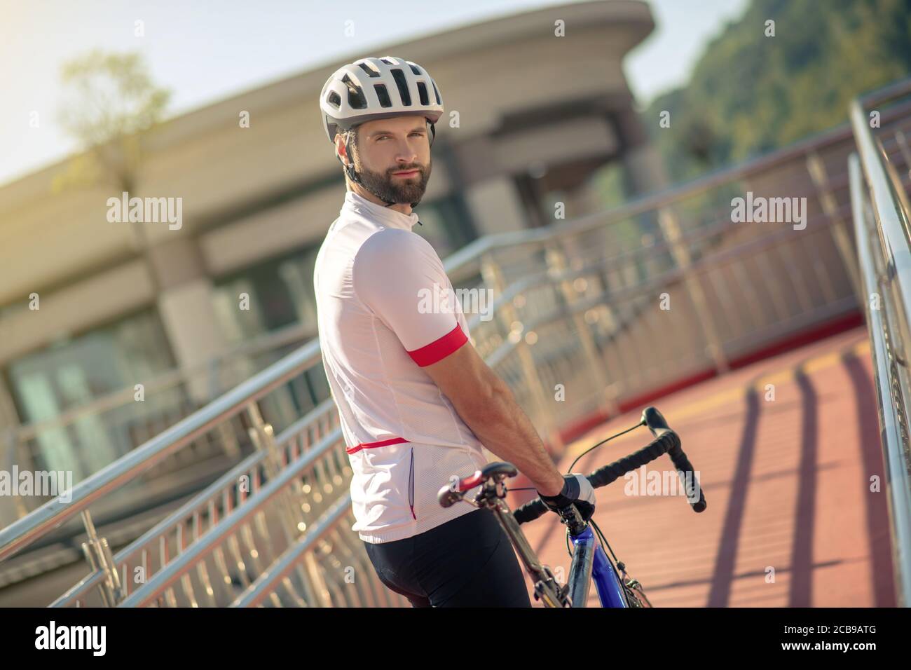Man in sports tshirt and helmet with bicycle Stock Photo - Alamy
