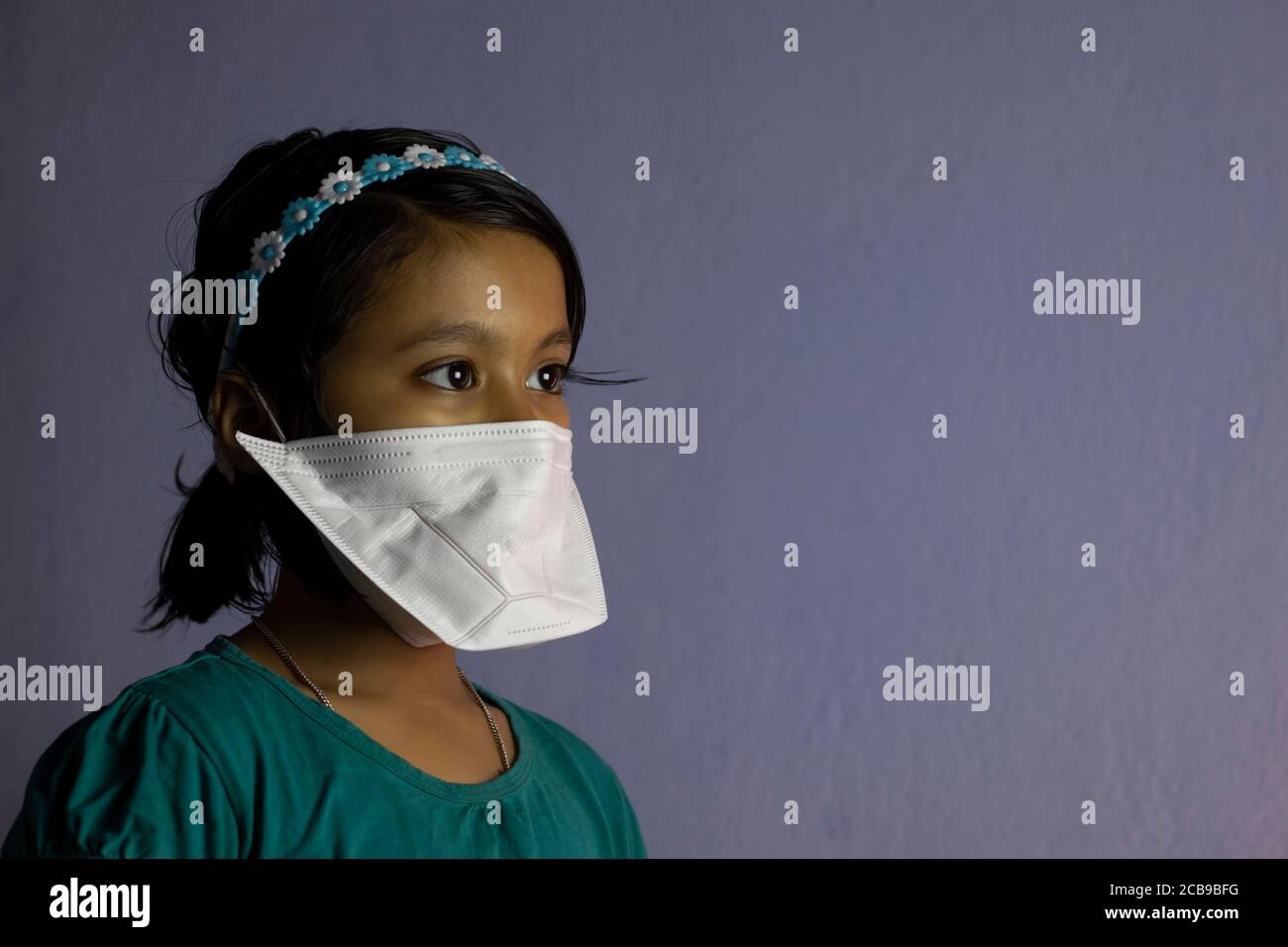 an Indian asian girl child wearing nose mask on white background Stock ...