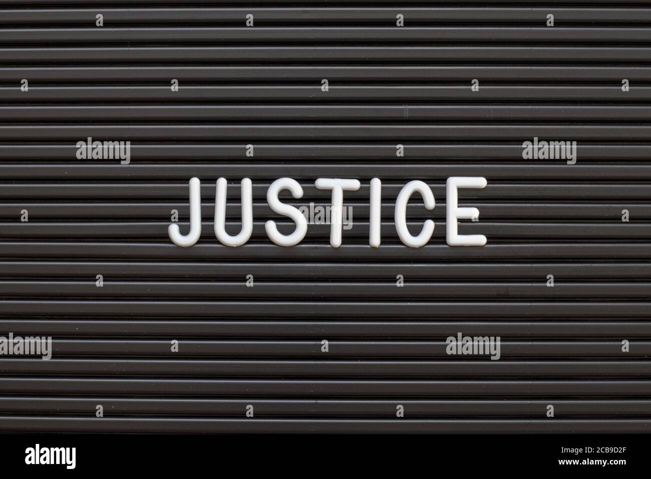 Black color felt letter board with white alphabet in word justice ...