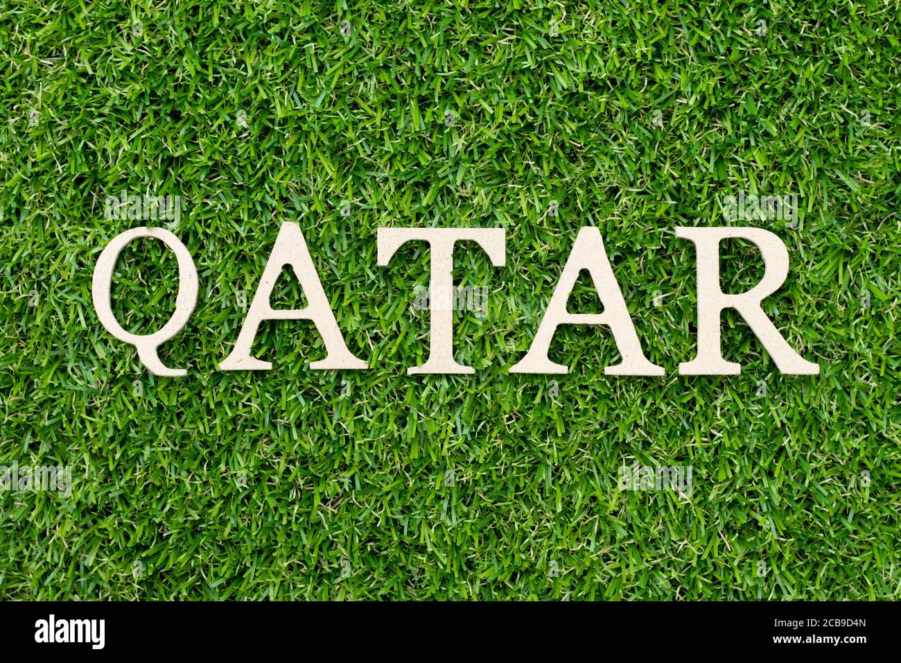 Wood alphabet letter in word Qatar on green grass background Stock ...