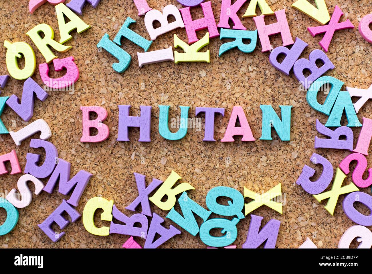 Color alphabet in word Bhutan with another letter as frame on cork ...