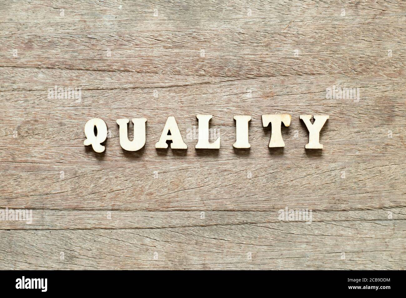 Letter block in word quality on wood background Stock Photo - Alamy