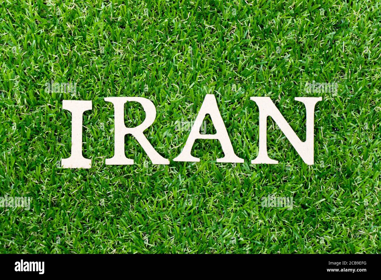 Wood letter in word Iran on green grass background Stock Photo - Alamy