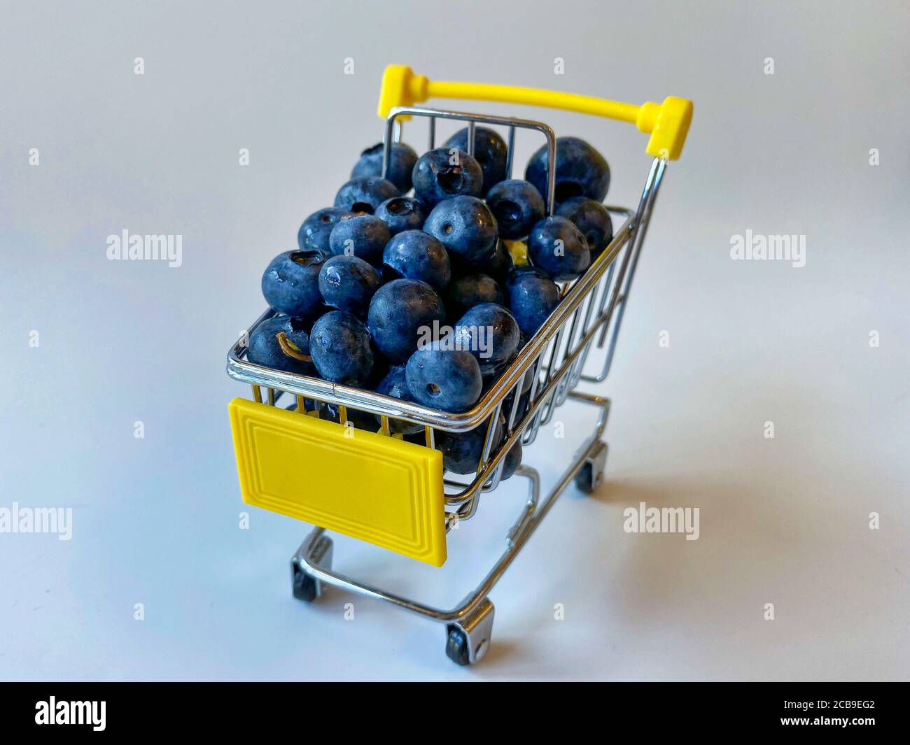 Miniature yellow shopping cart with full basket of blueberries Stock ...