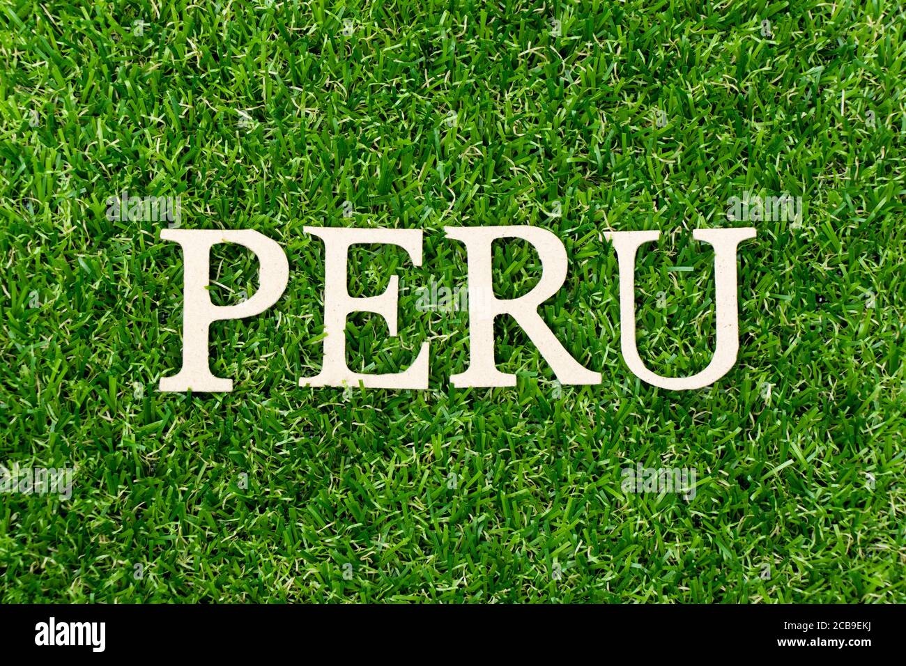 Wood letter in word Peru on green grass background Stock Photo - Alamy