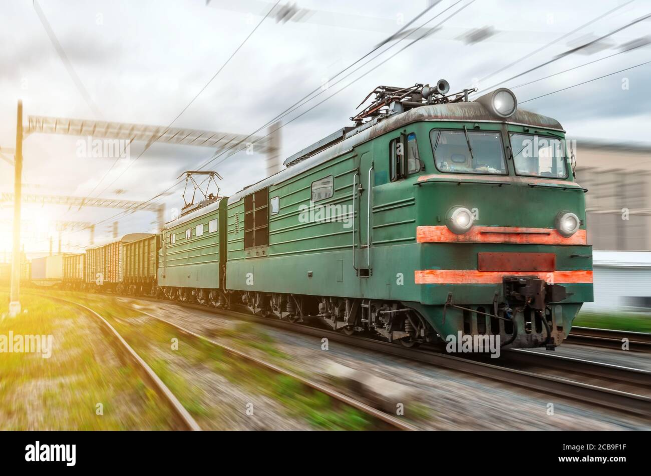 Locomotive electric with a freight train at high speed rides by rail ...