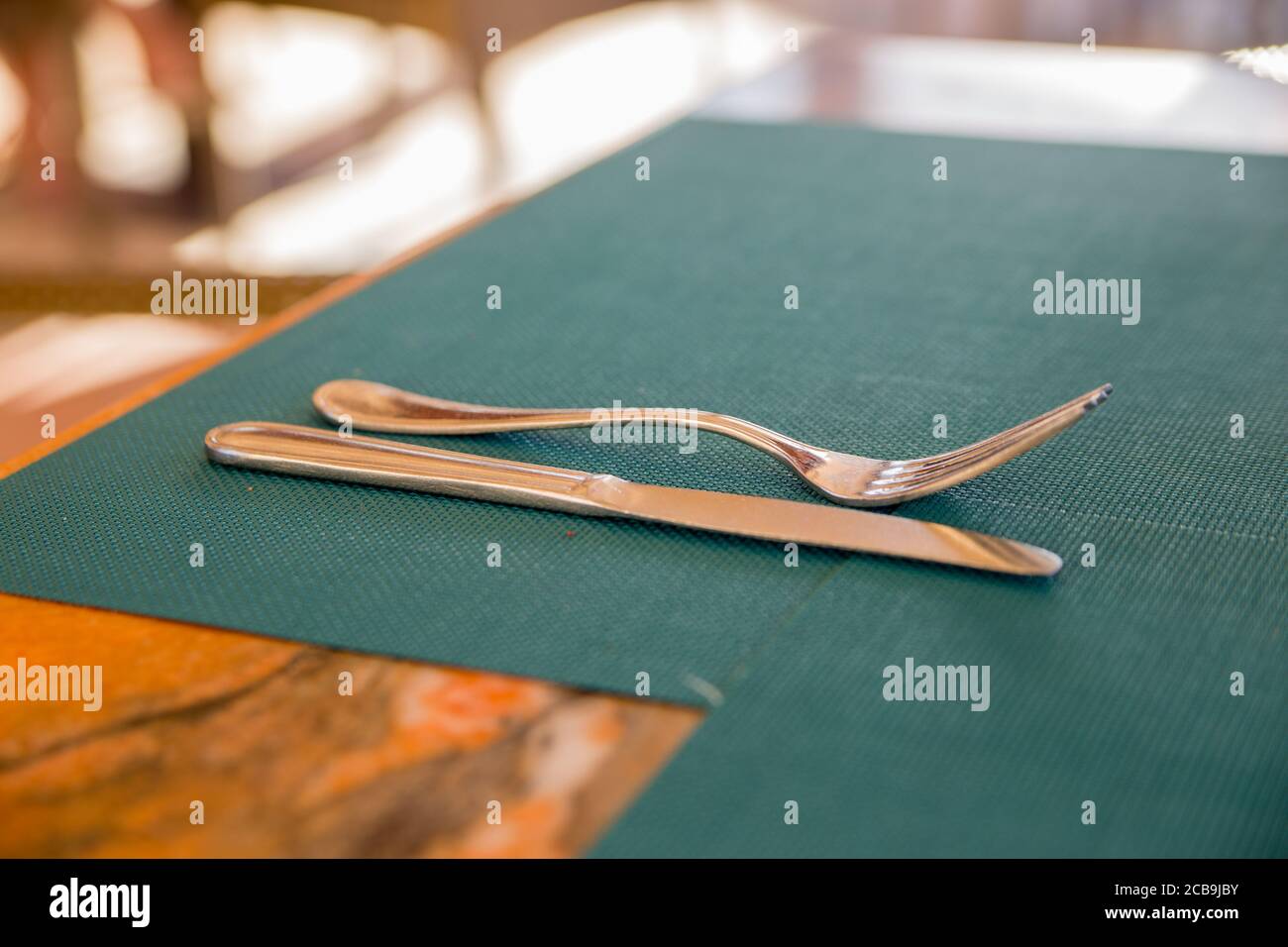 a knife and fork on an empty table Stock Photo - Alamy