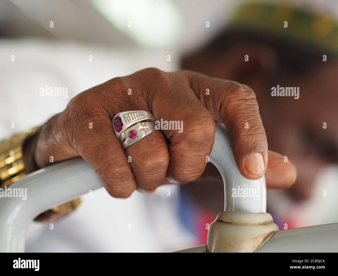Old male holding on to a railing for support Stock Photo - Alamy