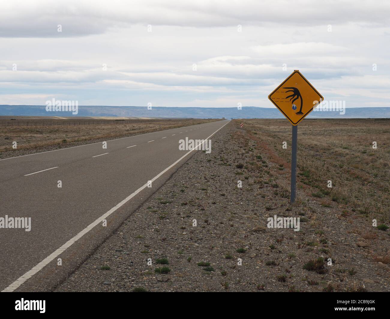 Closeup shot of 'windy' signage on the side of a road in the middle of ...