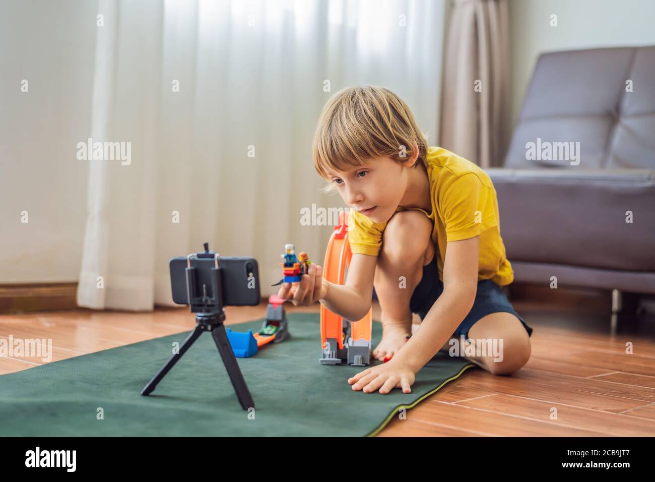 Staying connected. Happy young boy looking at his mobile phone and ...