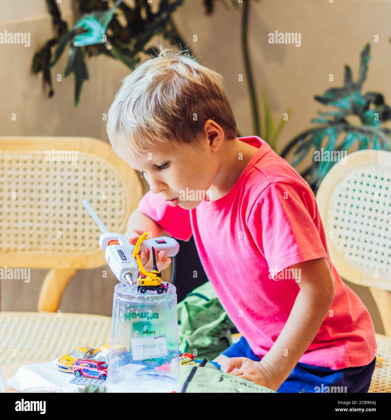Boy use hot melt glue gun making yourself DIY toys from recycled ...
