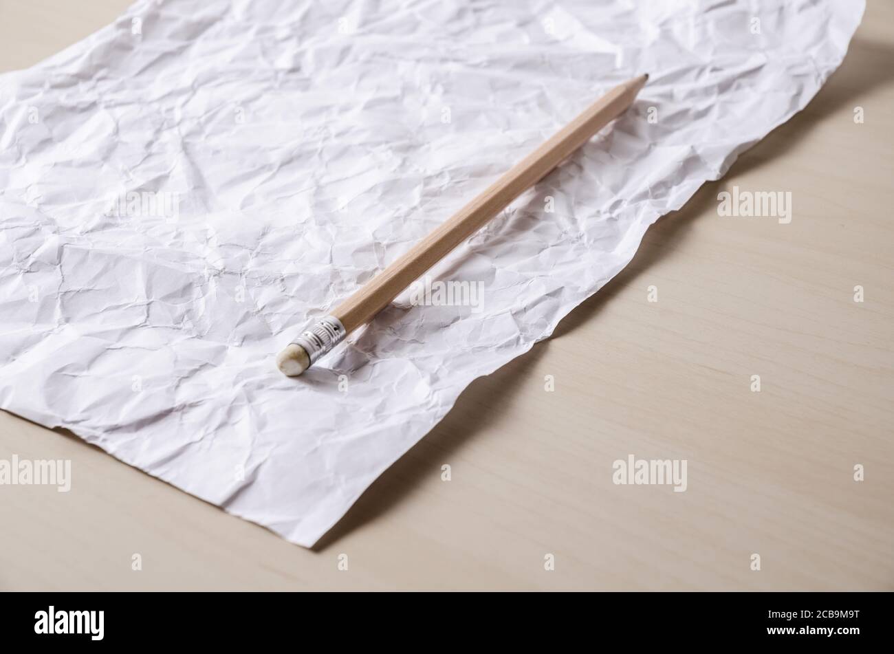 Crumpled paper and pencil on wooden desk, writing concept, indoors ...