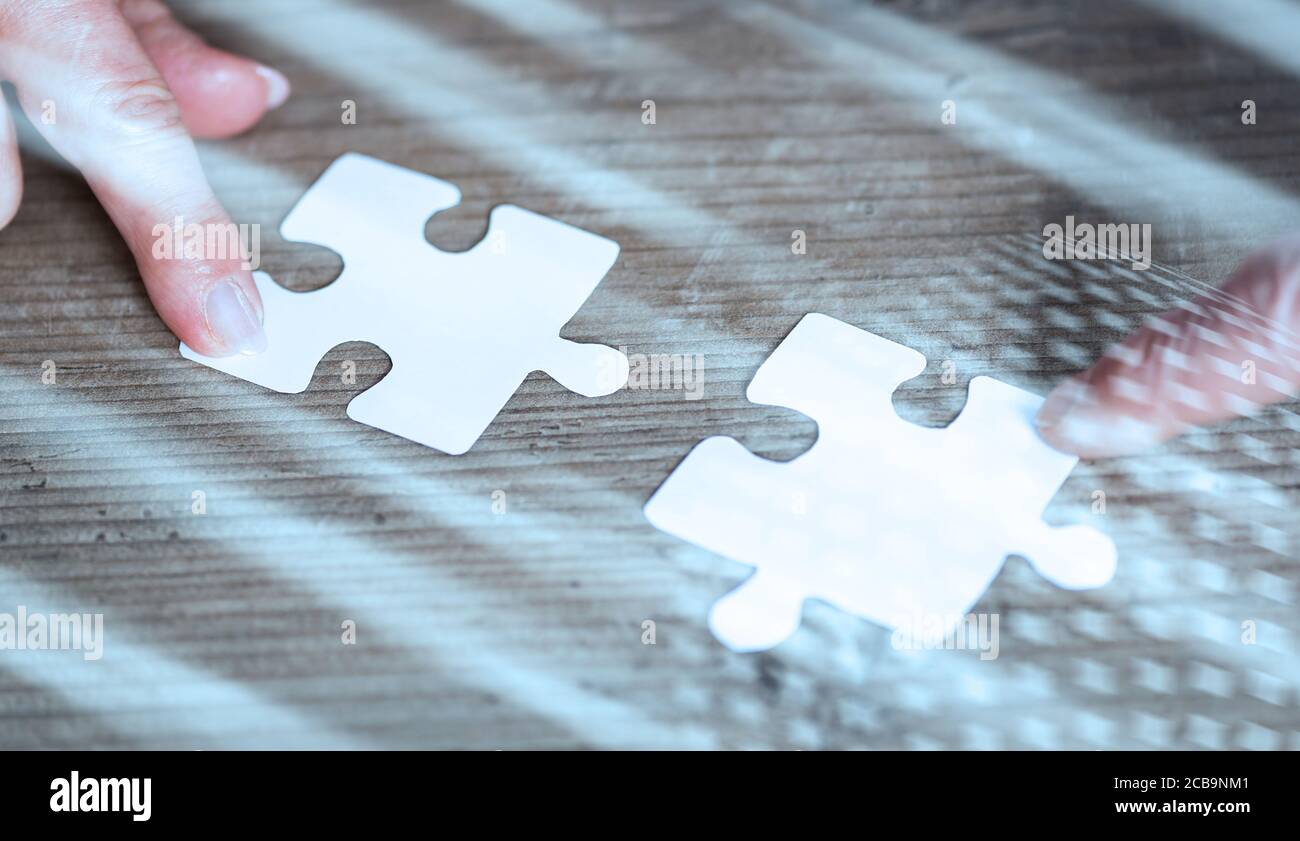 Hands joining two puzzle pieces, teamwork concept; light effect Stock ...
