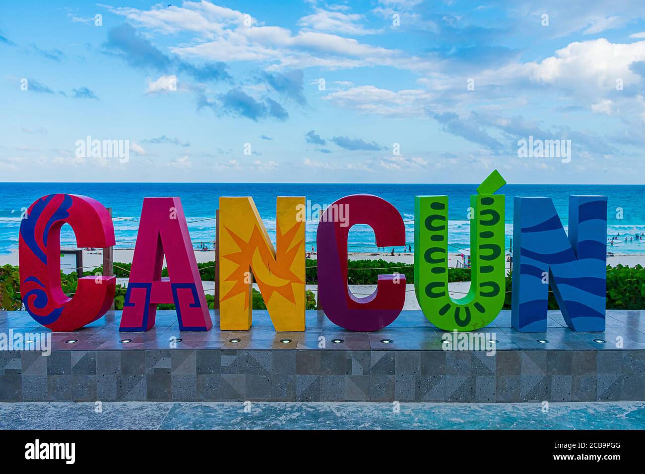 Closeup shot of the colorful word Cancun on the seashore on a bright ...