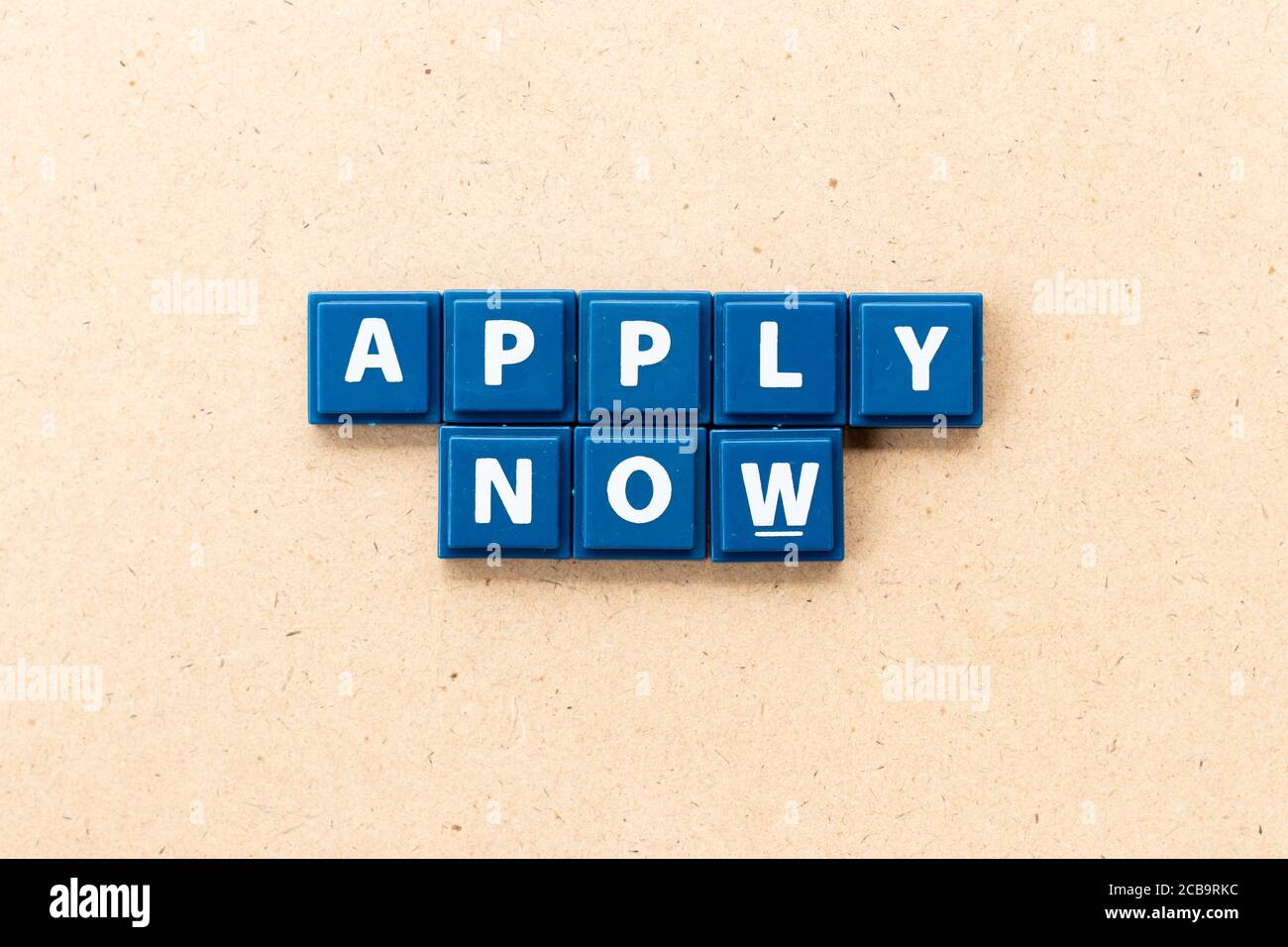 Tile letter in word apply now on wood background Stock Photo - Alamy