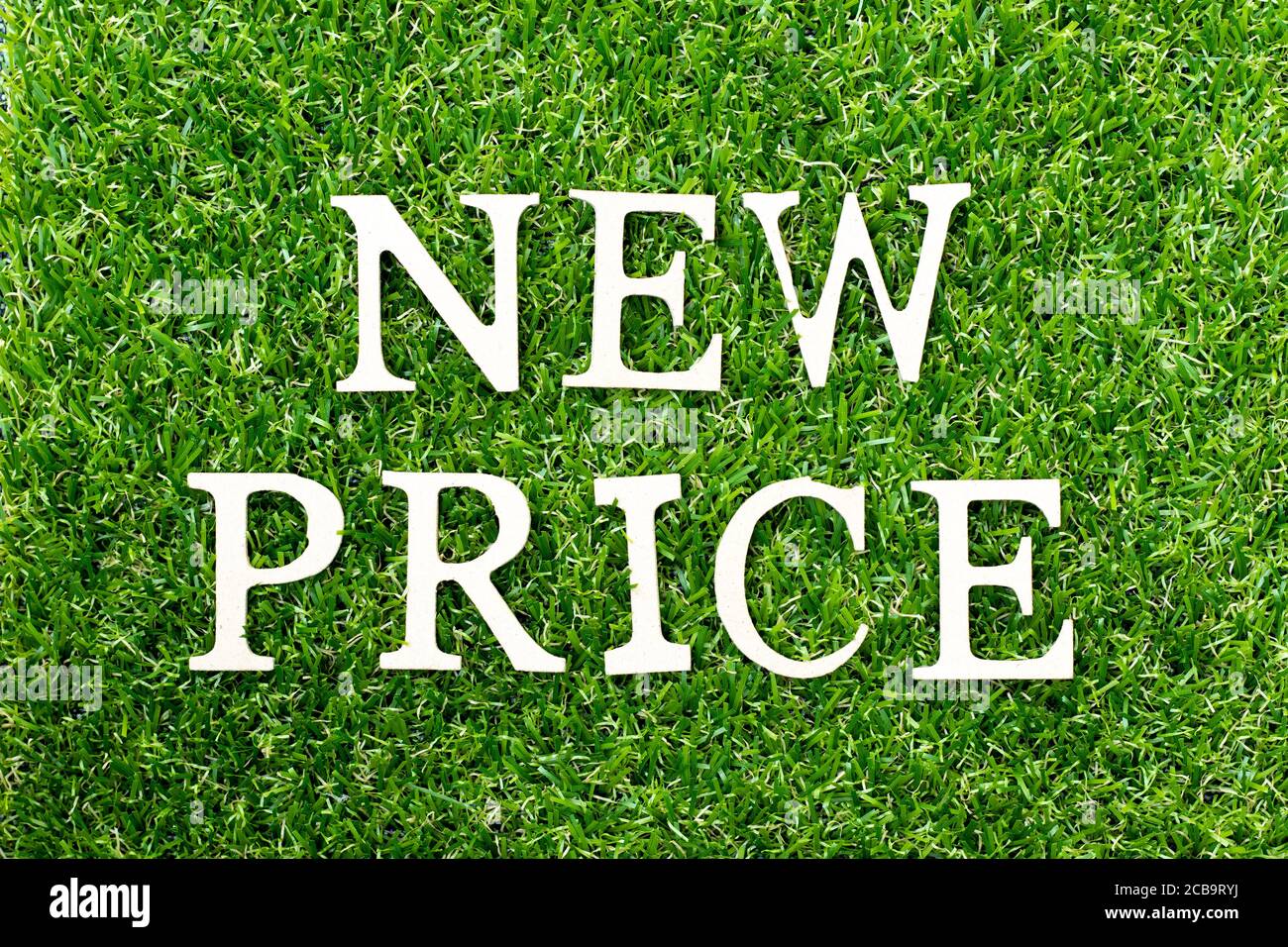 Wood alphabet letter in word new price on green grass background Stock ...